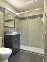 Um secador de cabelo, toalhas fornecidas, sabão, champô 