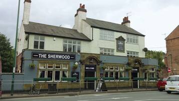 Um edifício de dois andares com uma placa que diz "The Sherwood".