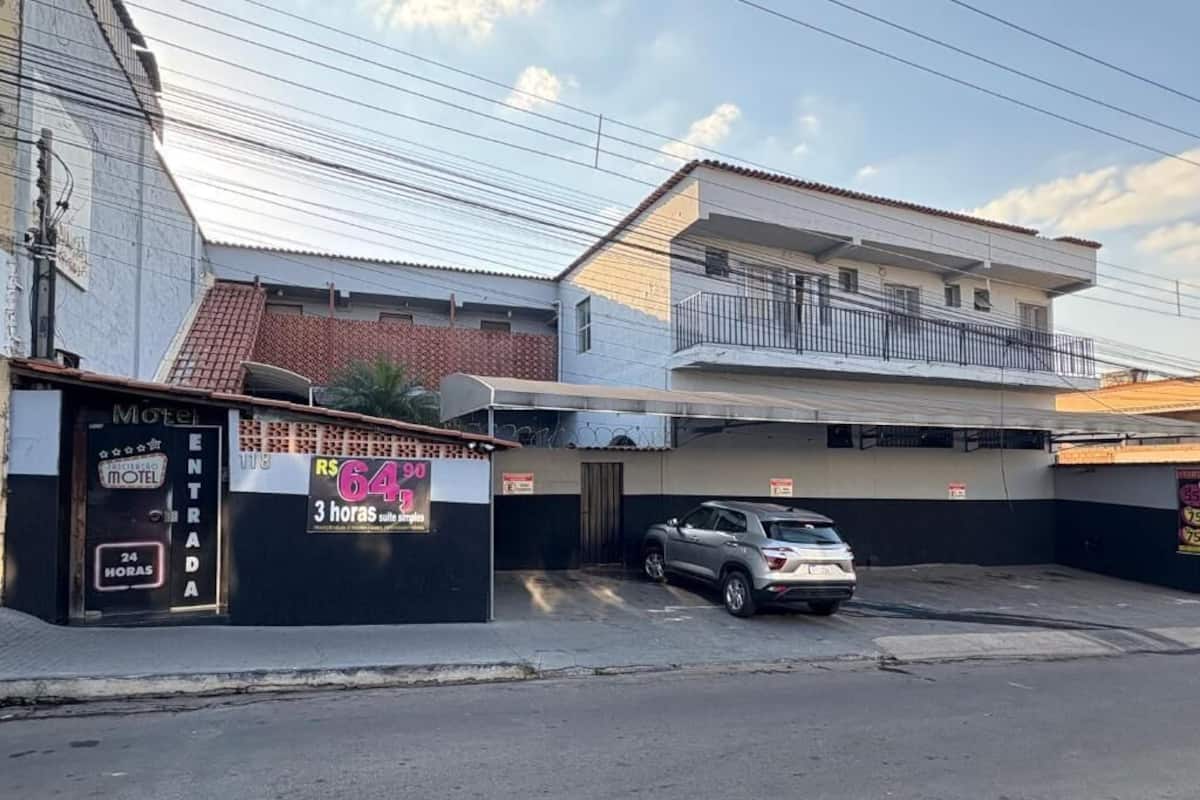 Um motel com um letreiro anunciando uma estadia de 3 horas por R$ 64,90.