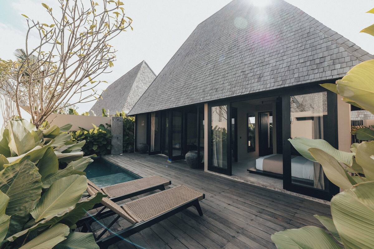 Uma villa moderna com piscina, grandes janelas e deck de madeira.
