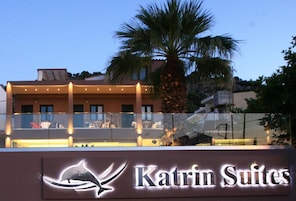 Placa de hotel com logotipo de golfinho e o nome 'Katrin Suites'.