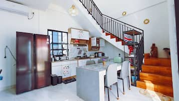 Um frigorífico/congelador grande, um micro-ondas, uma placa de cozinha