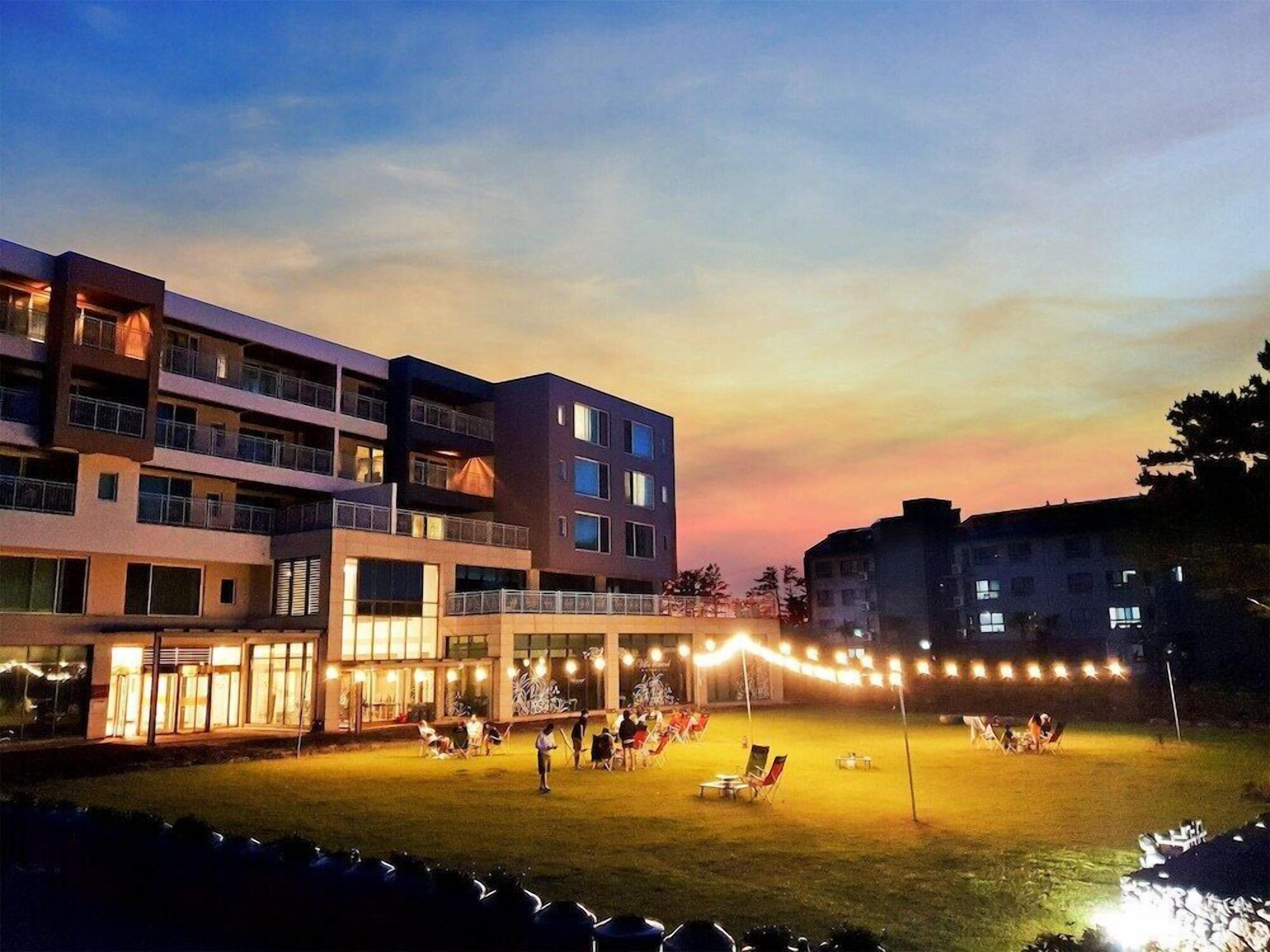 Um hotel com vários andares, varandas e um pátio bem iluminado.