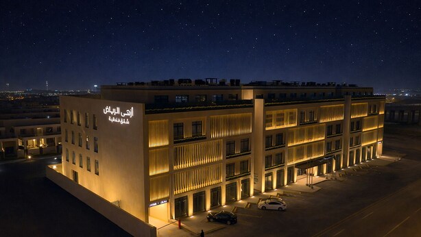 Um hotel com vários andares, varandas iluminadas e um céu noturno límpido.