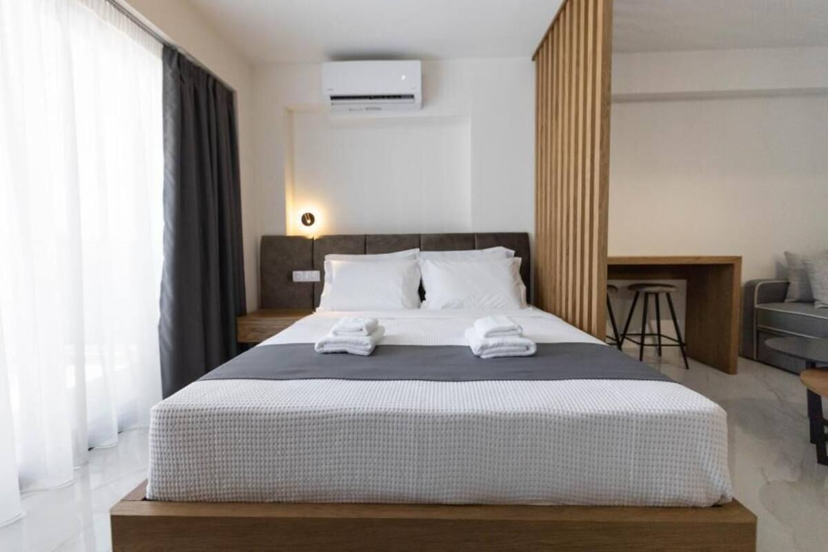 Quarto de hotel moderno com uma cama grande, uma mesa e uma cadeira.
