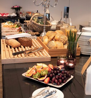 Mesa de buffet com diversos alimentos e utensílios.