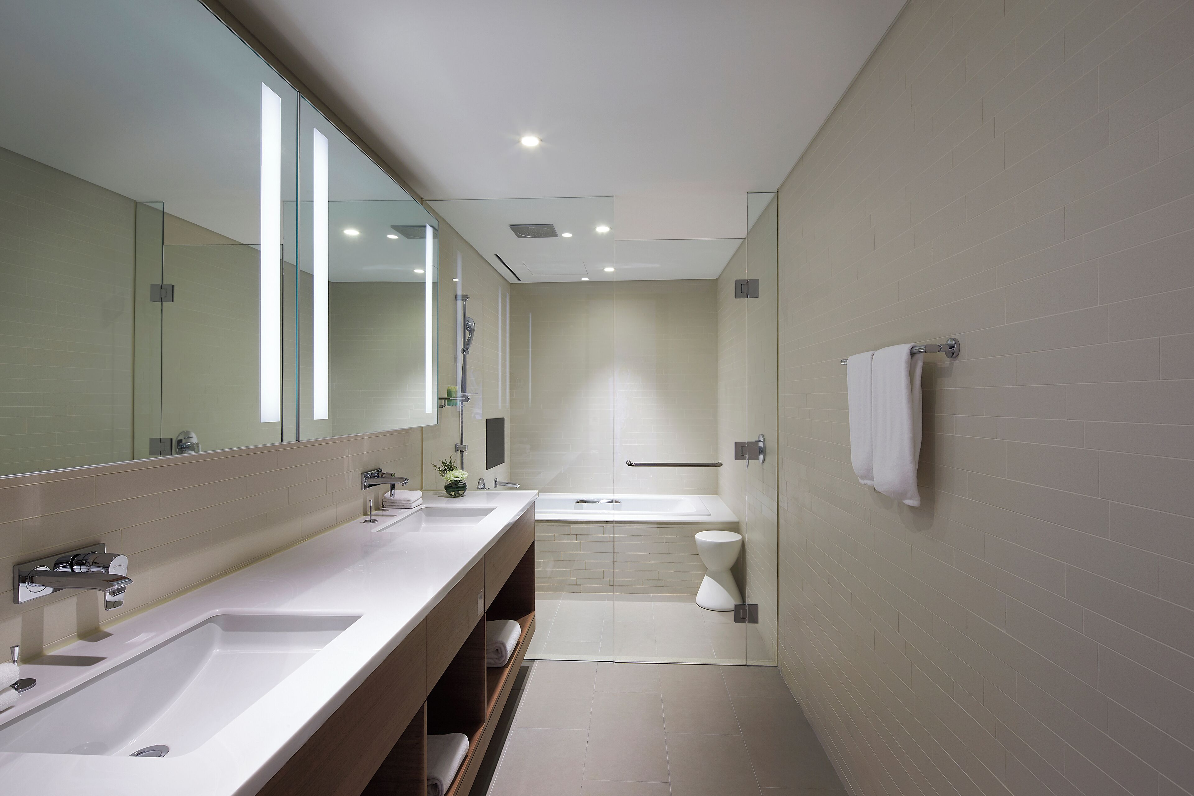 Uma casa de banho moderna com duas pias, uma banheira e uma sanita.