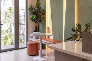 Um interior moderno com uma mesa de vidro, um banco e plantas em vasos.