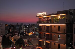 Um edifício com vários andares, varandas e uma placa com a inscrição 'Managed by CityHouse'.
