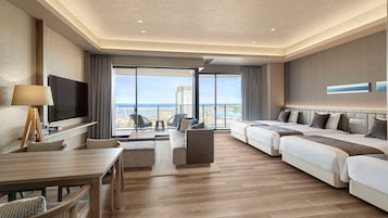 Quarto de hotel com varanda, televisão, escrivaninha e duas camas.