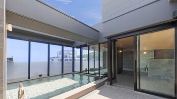 Um hotel moderno com piscina infinita coberta por vidro, vista para o mar e decoração contemporânea.
