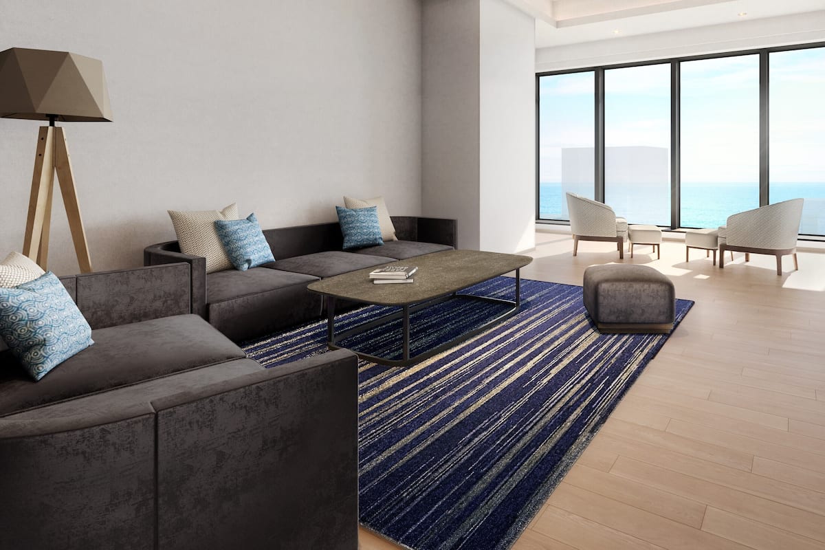 Uma sala de estar moderna com um sofá, poltronas, uma mesa de centro e uma luminária.