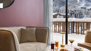 Uma sala de estar acolhedora com uma janela ampla que dá para uma paisagem montanhosa coberta de neve.