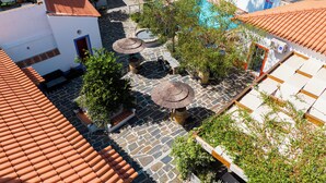 Pátio com piscina, piso de pedra e áreas de estar ao ar livre.