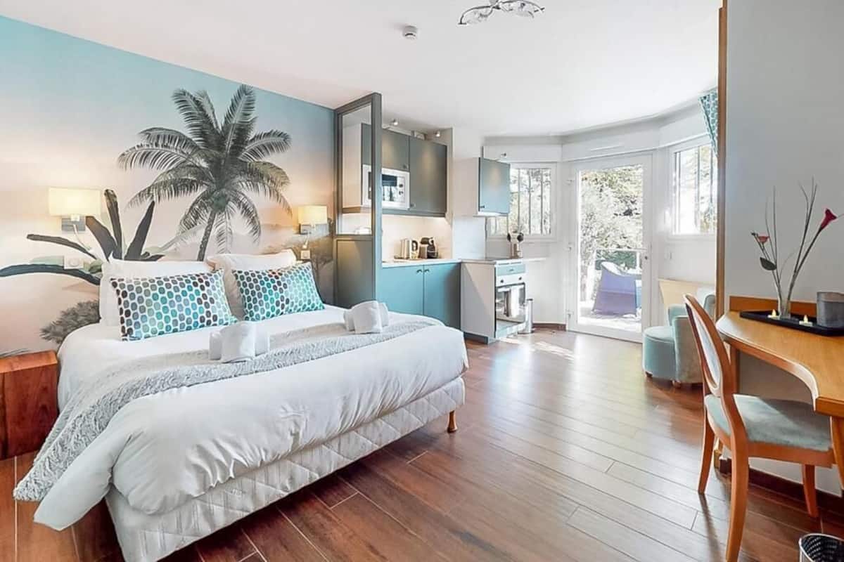 Quarto com uma cama grande, uma mesa de escritório e um espaço de refeições.