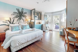Quarto com uma cama grande, uma escrivaninha e um espaço para refeições.