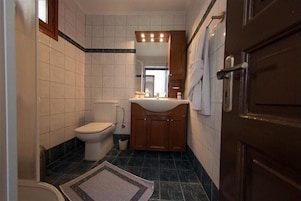 Uma casa de banho compacta com sanita, lavatório e espelho.