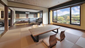 Um interior moderno com uma grande mesa de jantar, assentos acolchoados e vista para uma paisagem montanhosa através de amplas janelas.