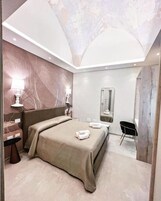 Um quarto moderno com uma cama grande, abajures, um espelho e uma escrivaninha.
