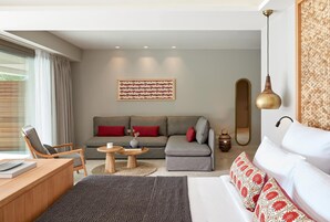 Uma sala moderna com sofá, mesa de centro, poltrona e cama.