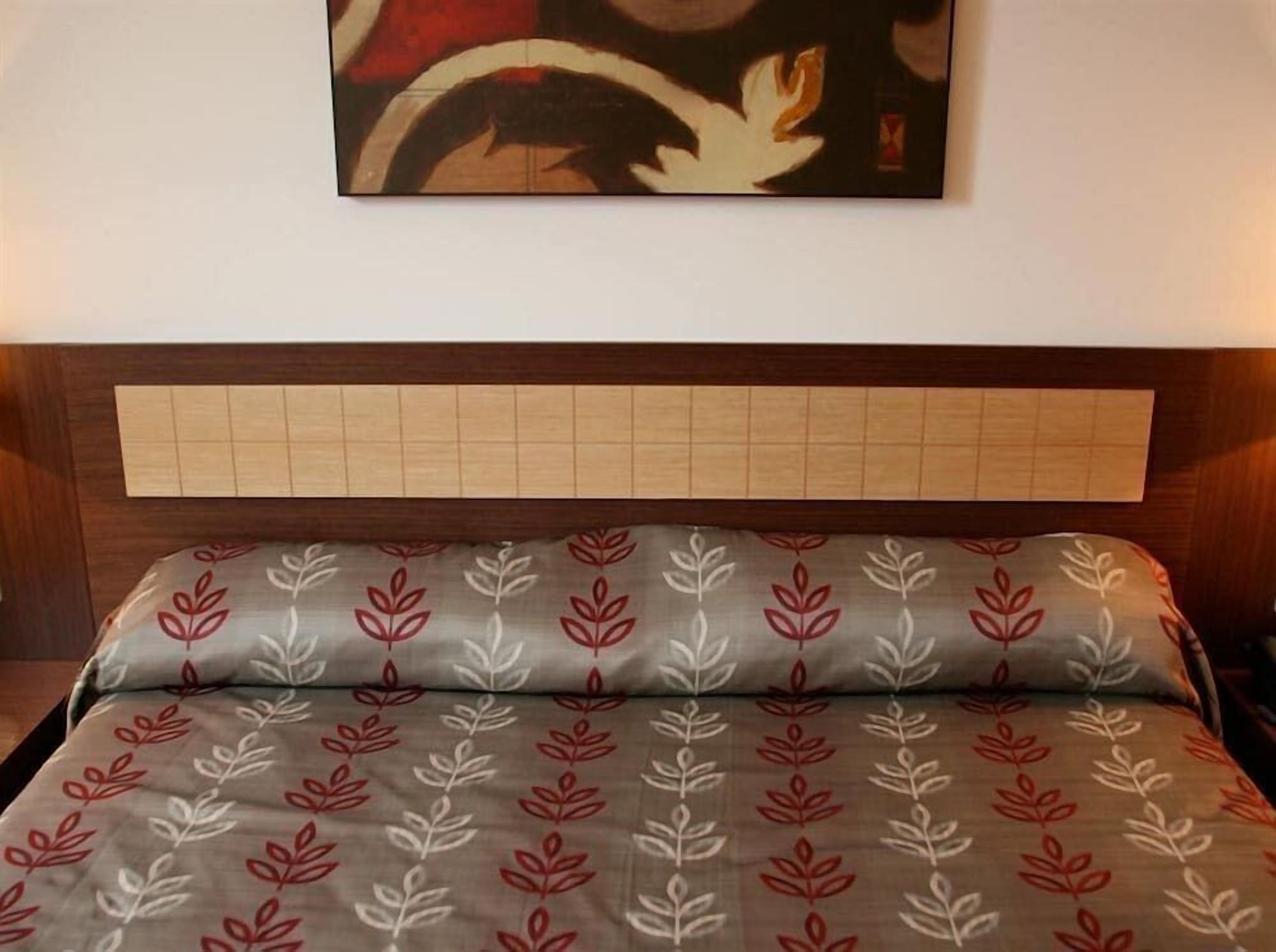 Uma cama com colcha estampada e cabeceira com design em grade.