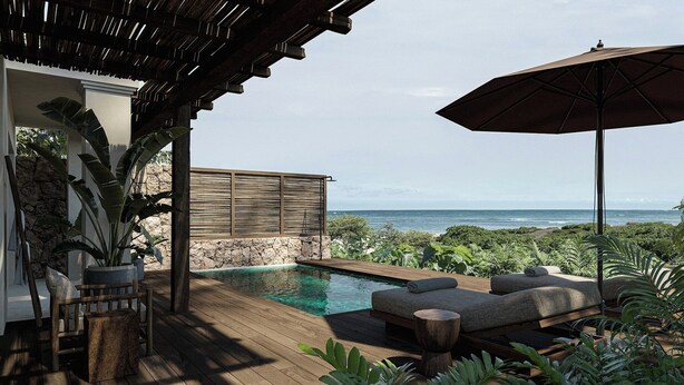 Um deck de madeira com piscina, área de estar ao ar livre e vista para o oceano.