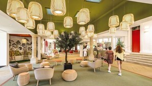 Um hall amplo com luminárias de vime penduradas, assentos confortáveis e uma árvore central.