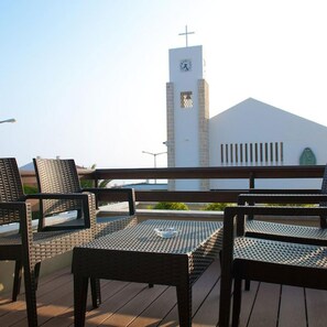 Mesas ao ar livre com vista para uma torre de igreja.