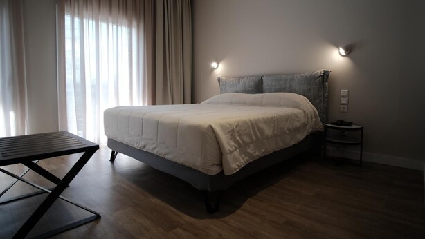 Quarto moderno com cama, mesa de cabeceira e abajur.