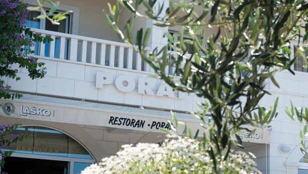 Um edifício com uma placa que indica 'PORA RESTORAN' e 'LASKO', mostrando um restaurante e um spa.