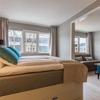 Quarto com cama, janela, sofá e vista para o exterior.