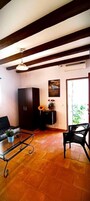Uma sala de estar com sofá, mesa de centro, aparador e cadeira.