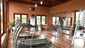 Uma academia com esteiras, halteres e aparelhos de musculação.