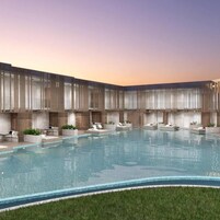 Uma área interna de piscina moderna, com piscina transparente, espreguiçadeiras e um gramado na frente.