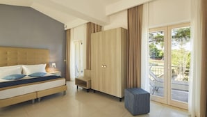 Quarto moderno com cama, guarda-roupa e um pequeno espaço para sentar.