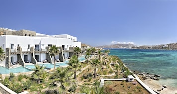 Um resort com piscina, edifícios brancos e vista para o mar.