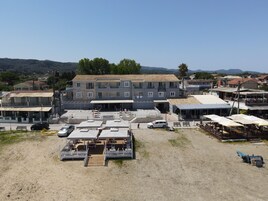 Um hotel à beira-mar com um edifício grande, área de estar ao ar livre e uma faixa de areia.