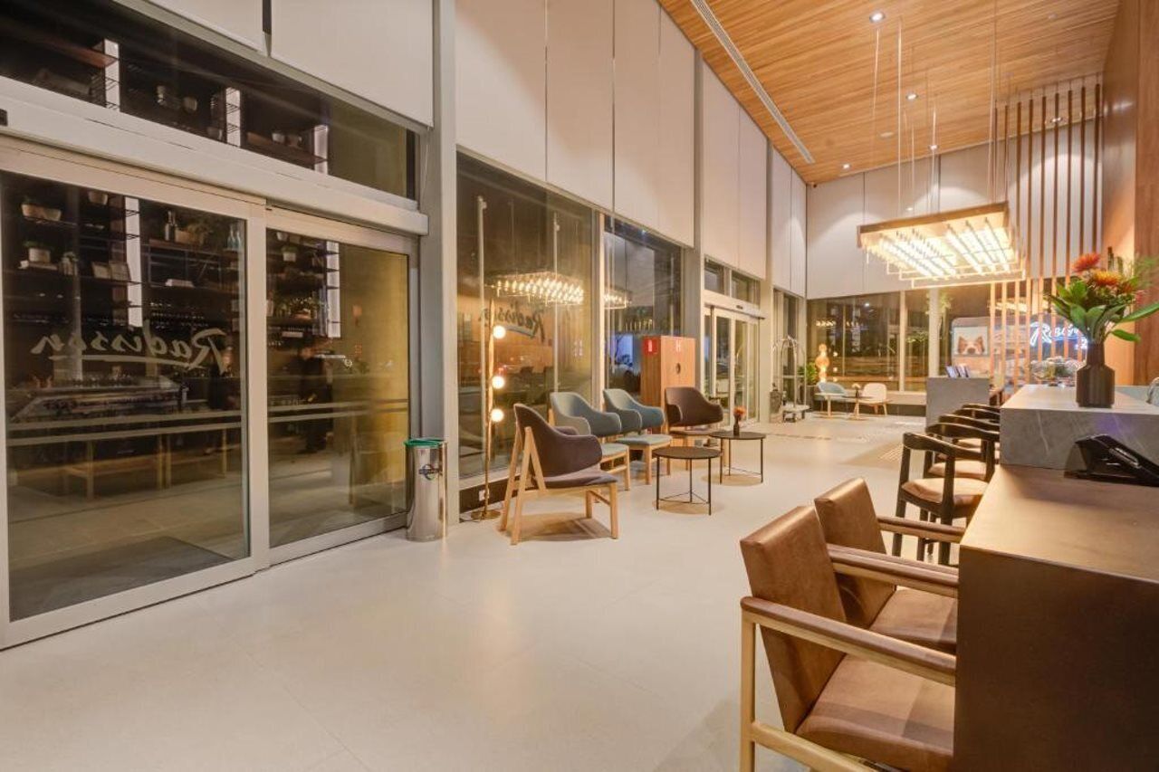 Um interior moderno com balcão de atendimento, área de estar e grandes janelas.