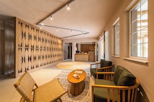 Um interior moderno com um painel de parede de madeira, uma mesa de centro redonda e área de estar.