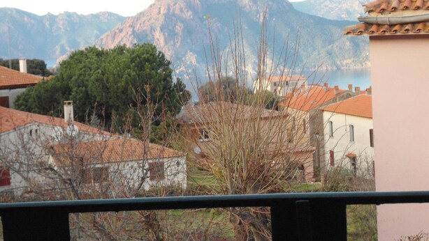 Zona residencial com casas, uma cordilheira e um corpo d'água ao fundo.