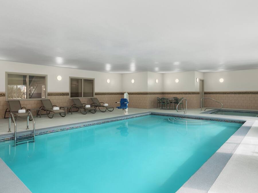 Piscina com espreguiçadeiras e um vestiário.