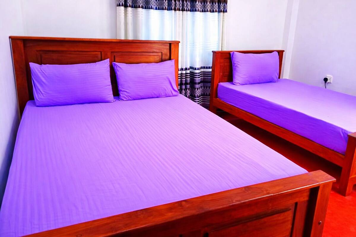 Uma cama de casal com estrutura e cabeceira de madeira, acompanhada por dois travesseiros.