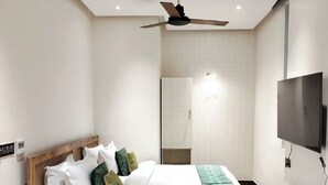Quarto com cama, cabeceira de madeira, mesa de cabeceira e ventilador de teto.