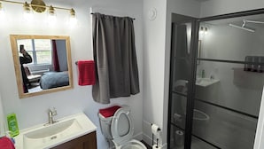 Uma casa de banho moderna com lavatório, sanita e chuveiro.