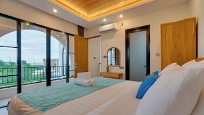 Quarto moderno com uma cama grande, cabeceira de madeira, mesa de cabeceira e espelho.
