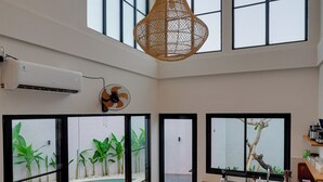 Cozinha espaçosa com grandes janelas, área de jantar com mesa posta para dois e vista para uma piscina.