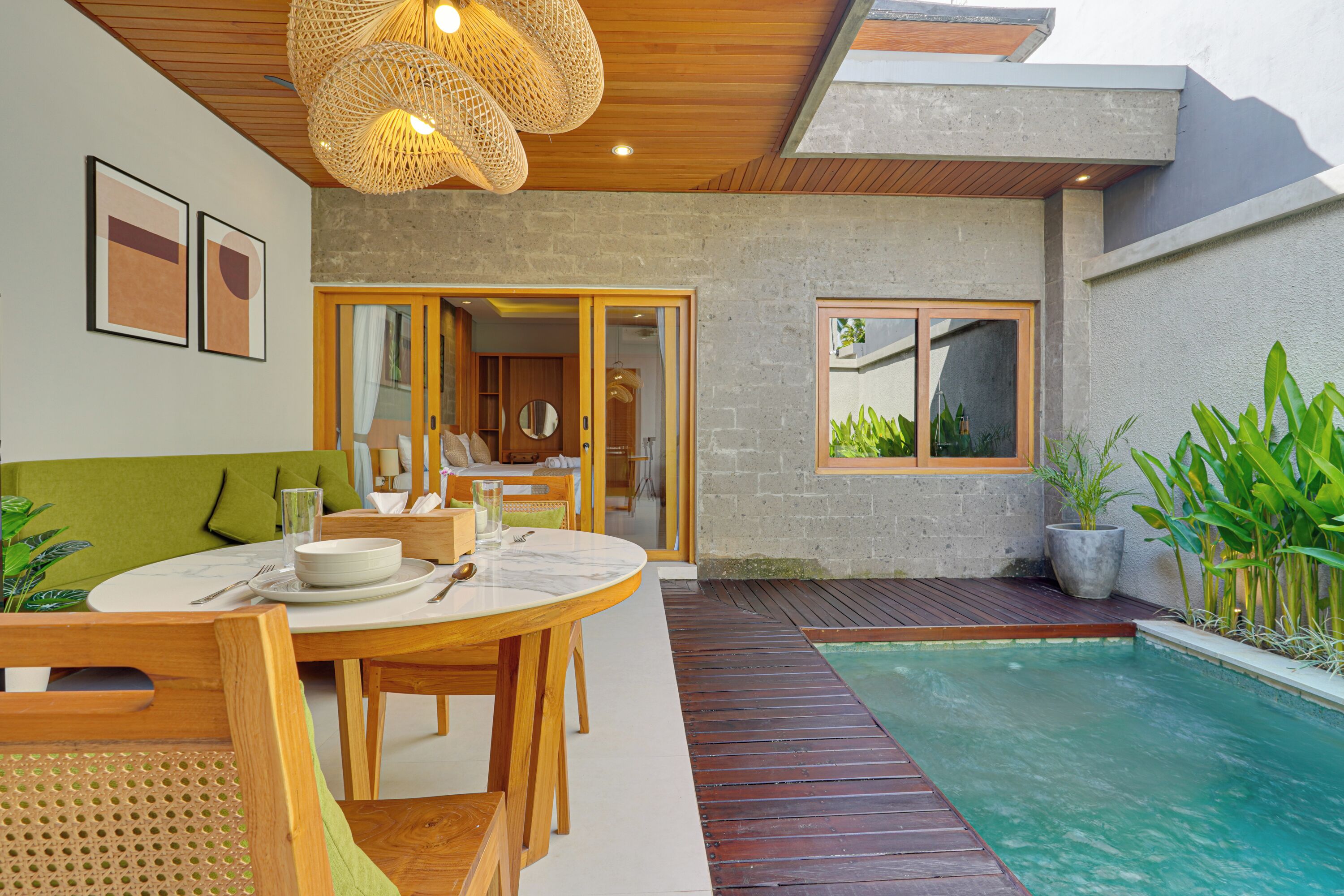 Uma área moderna para refeições ao ar livre, com piscina, deck de madeira e vista para o interior.