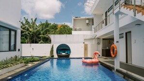 Piscina com hidromassagem, boia de flamingo e boia salva-vidas.