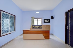 Bancada de recepção com sinalização indicando ser área de recepção de hotel.
