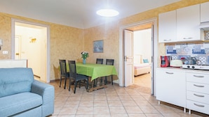 Um espaço compacto com área de jantar, cozinha compacta e sofá.